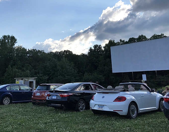As twilight approaches, cars nestle into their spots while dramatic clouds promise an unforgettable evening of double features.