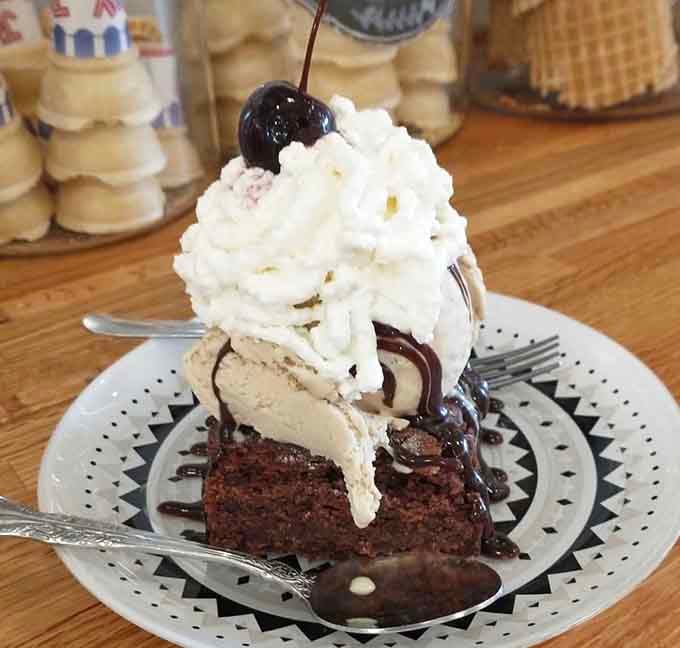 This brownie sundae towers like a delicious skyscraper, and you're about to demolish it gloriously.