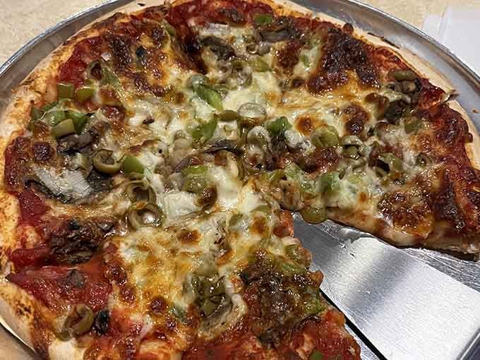 A loaded pizza with mushrooms, green peppers, and olives that looks like it means serious business. Wisconsin delivers again.