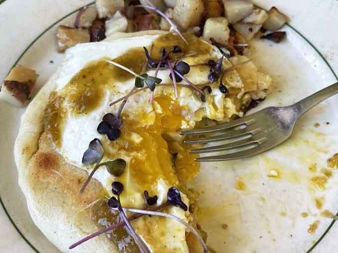 That golden arepa topped with bacon and runny eggs is basically edible sunshine on a plate.