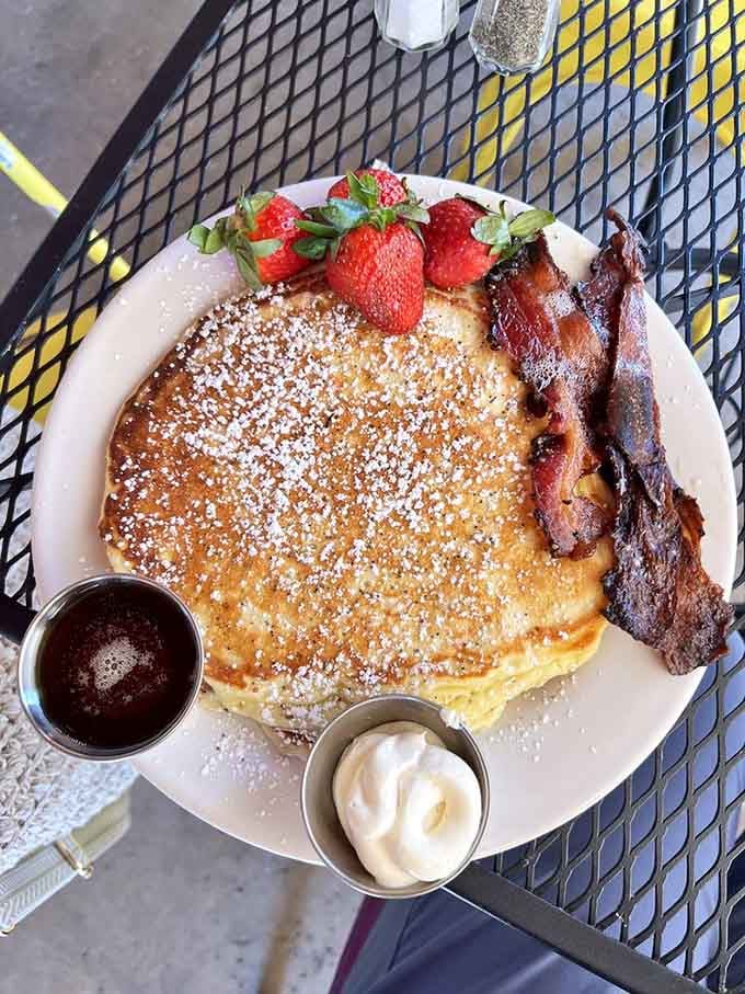 Golden pancakes dusted with powdered sugar and crowned with strawberries, the kind of breakfast that makes Monday mornings almost bearable.