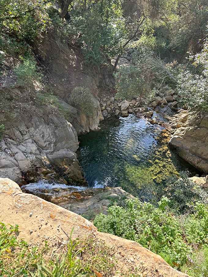 Emerald waters nestle between ancient rocks, creating swimming holes that make hotel pools look tragically boring by comparison.