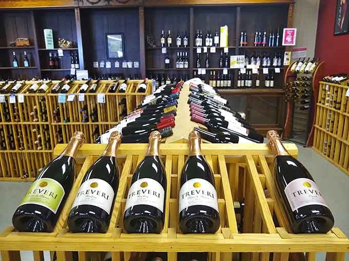 Local wines displayed on wooden racks, because sometimes your road trip needs a sophisticated souvenir or three.
