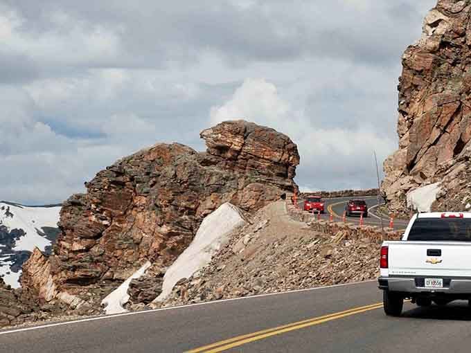 Ancient rock formations tower beside the pavement like nature's own roadside sculptures, reminding drivers they're just passing through geological history.