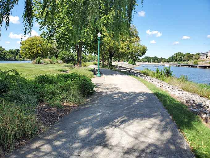 Where weeping willows frame your waterfront stroll like nature's own curtains, dappling sunlight across paths made for meandering slowly.