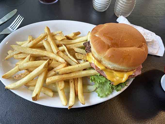 A burger so perfectly constructed it deserves its own architectural award, complete with a mountain of crispy fries.