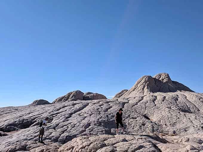 Tiny humans on ancient rocks: the ultimate perspective check that makes your daily problems seem wonderfully insignificant.