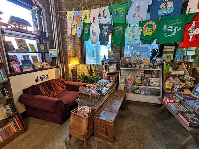 Vintage book-themed tees hang overhead while a plush couch invites you to settle in like Goldilocks found her chair.