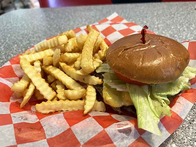 A classic burger with crinkle-cut fries served in a red checkered basket&mdash;simplicity executed to absolute perfection.