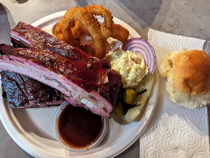 Ribs with that perfect smoke ring, onion rings for crunch, and a soft roll, this plate understands balance.