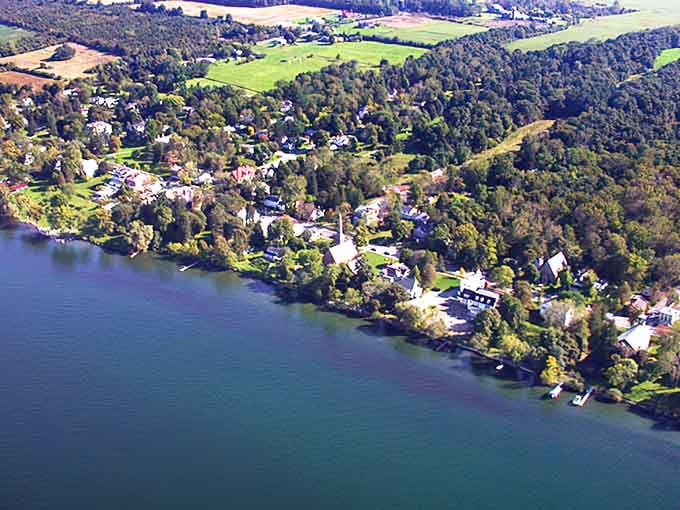 Lakeside village nestled in green hills looks like someone's idealized painting of peace and quiet come to life.
