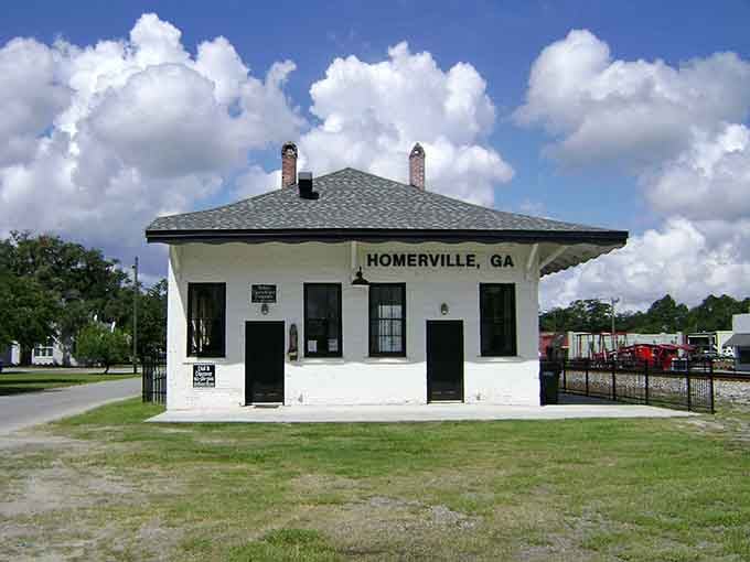 This classic white depot building stands as Homerville's proud landmark beneath dramatic summer clouds that paint the sky.