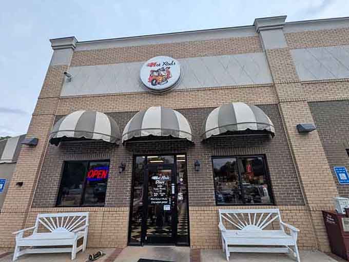 Those striped awnings and white benches outside create a welcoming vibe that says "sit, stay, eat well, friend."