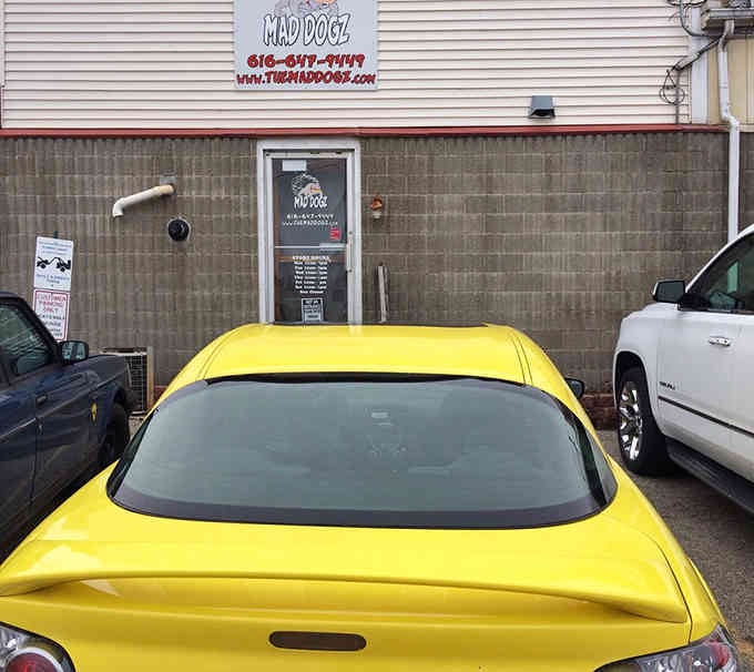 That bright yellow sports car knows where the good stuff is, parked right outside this unassuming hot dog treasure.