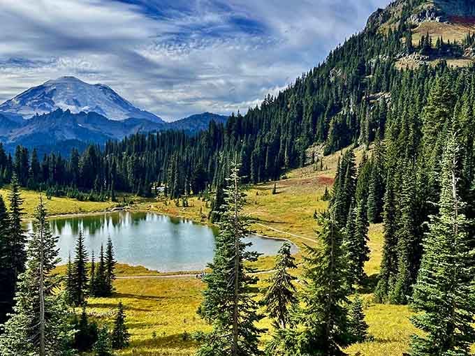 Mount Rainier peeks through the pines at this alpine lake, playing hide-and-seek with hikers.