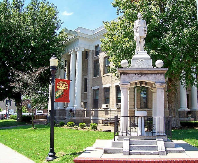 The Confederate monument stands sentinel before Greek Revival columns, marking layers of history in this thoughtful town square.