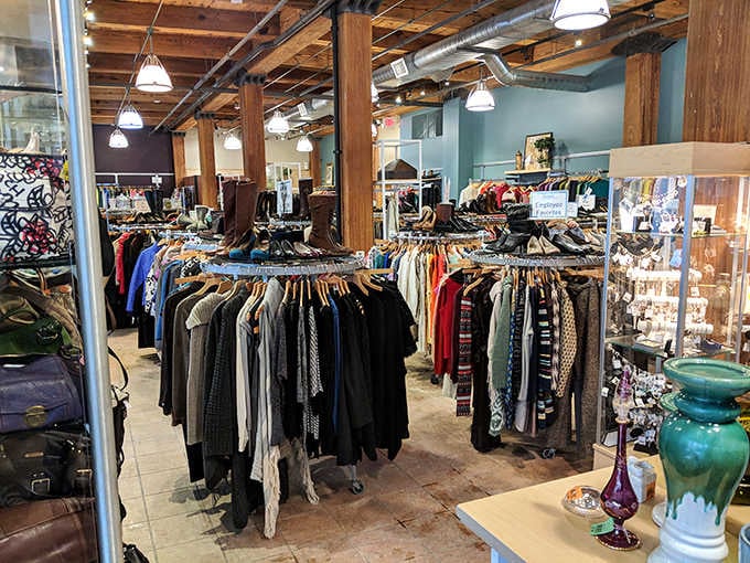 Warm pendant lights glow over clothing racks and glass jewelry cases inside this beautifully rustic Milwaukee gem.