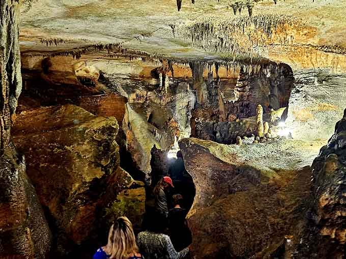 Explorers navigate through passages where flowstone formations create a landscape that looks almost extraterrestrial in its beauty.