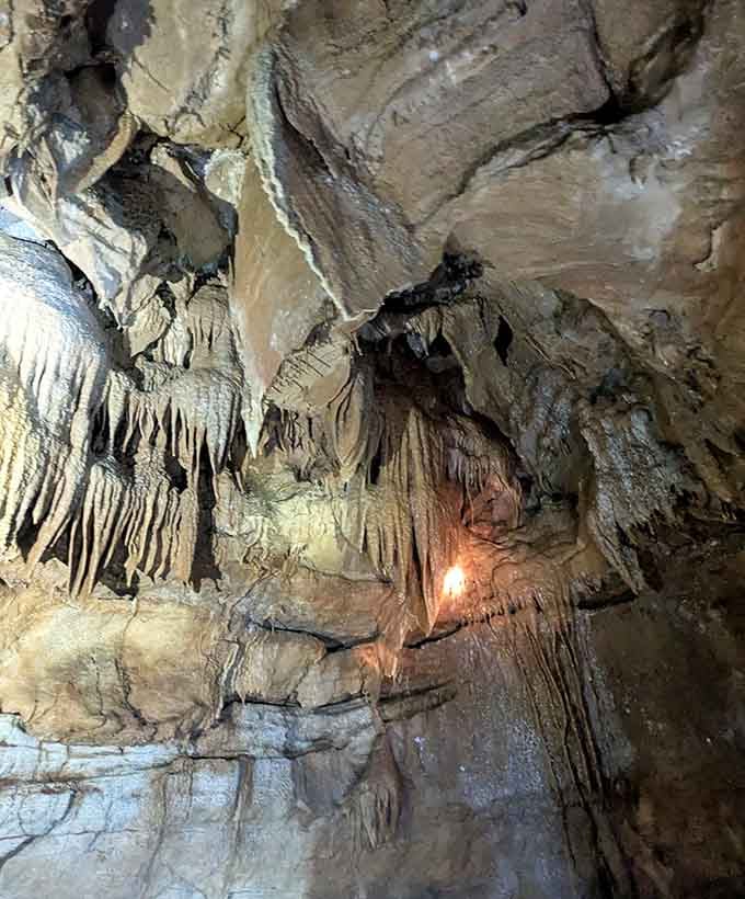 Delicate formations cascade down the walls like frozen waterfalls, each ridge and fold telling stories written in mineral deposits.