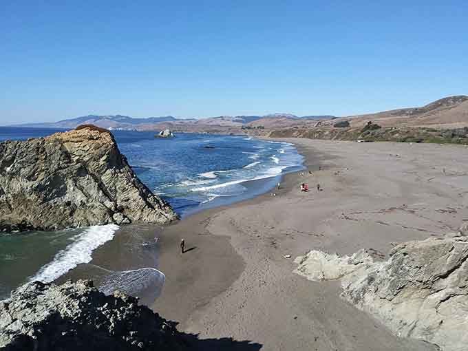 Dramatic rock formations frame this wild beach where nature shows off its most impressive coastal architecture.