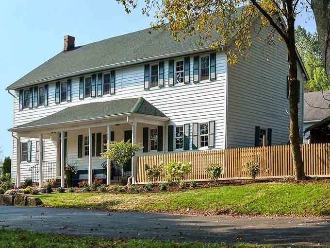 This classic white colonial home with green shutters looks ready for a Norman Rockwell painting session.
