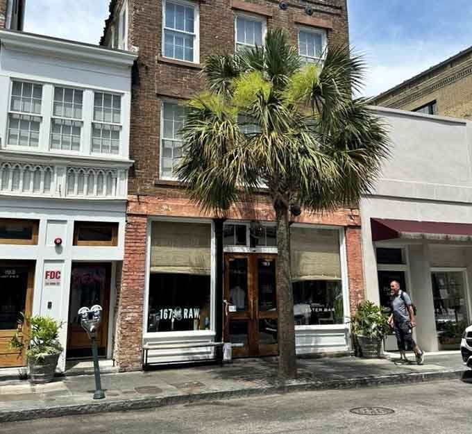The palmetto tree framing this entrance adds Southern charm to your raw bar experience on cobblestone streets.