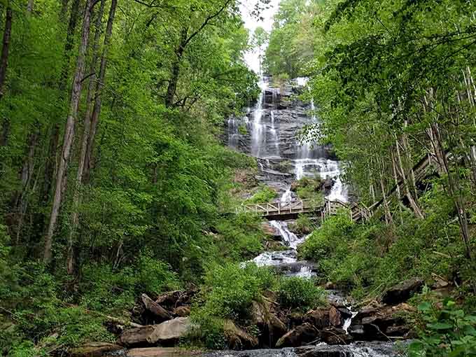 The full majesty of Georgia's tallest waterfall reveals itself through the forest, with observation platforms offering spectacular views.