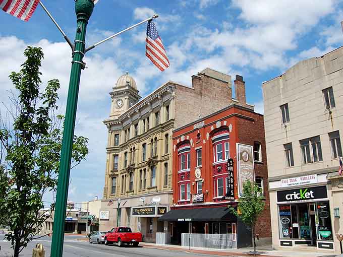 The American flag waves over historic buildings where small-town pride and affordable apartments go hand in hand perfectly.