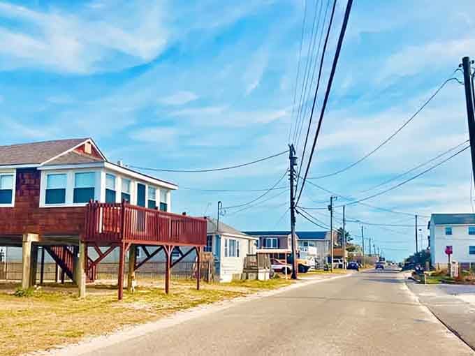 Beach houses on stilts dot the quiet coastal road where salt air and simple living create the perfect escape.