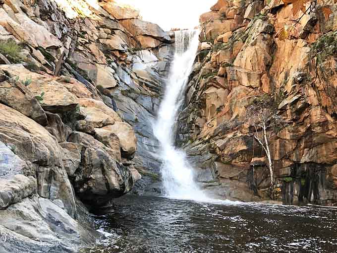 The waterfall carves through layered rock like nature's own sculpture, creating a pool that's been Instagram-ready for millennia.