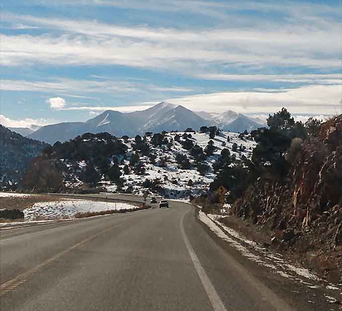 Winter's first kiss dusts the mountains while the winding road below promises adventure around every bend.