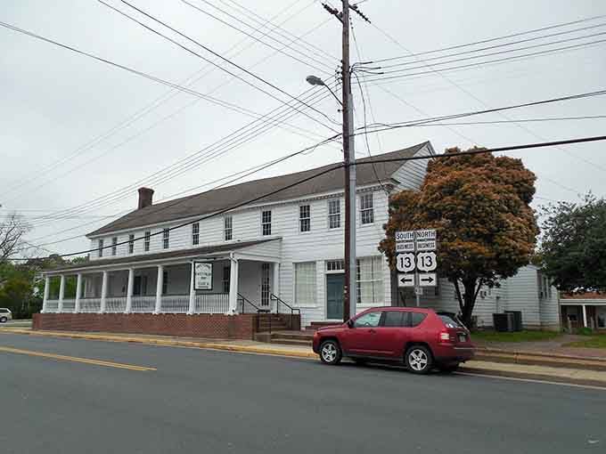 White-painted buildings and mature trees create a serene tableau that transports you back to a gentler era.