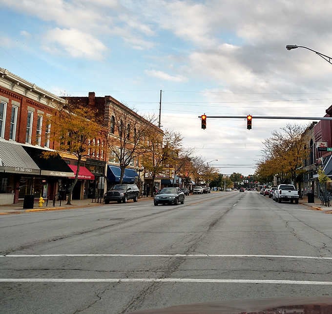 Autumn trees frame the wide street where locals still park downtown instead of circling endless suburban parking lots.