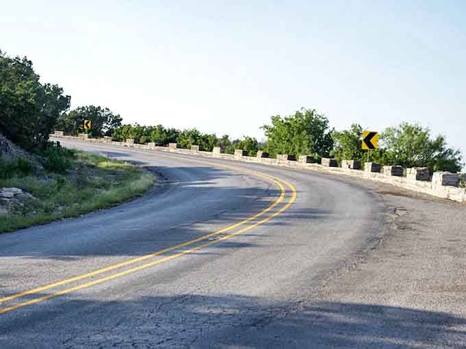 That sweeping curve with its warning sign promises an adventure through canyon country where geology writes stories in stone.