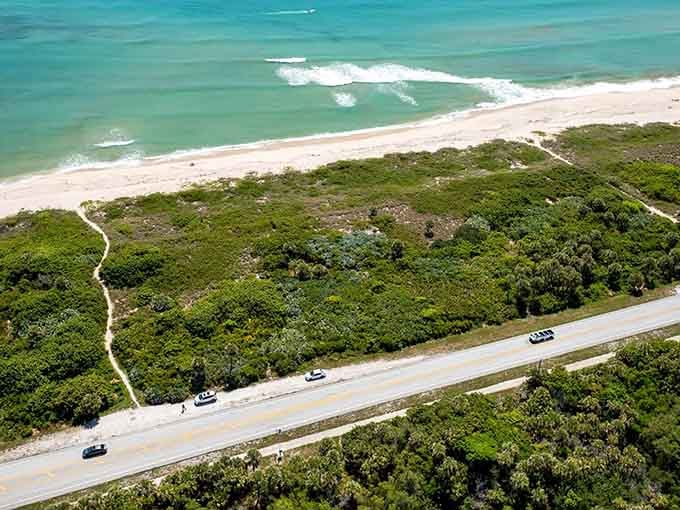 Wild coastal vegetation hugs the roadway while Atlantic waves crash onto untouched beaches just steps away.