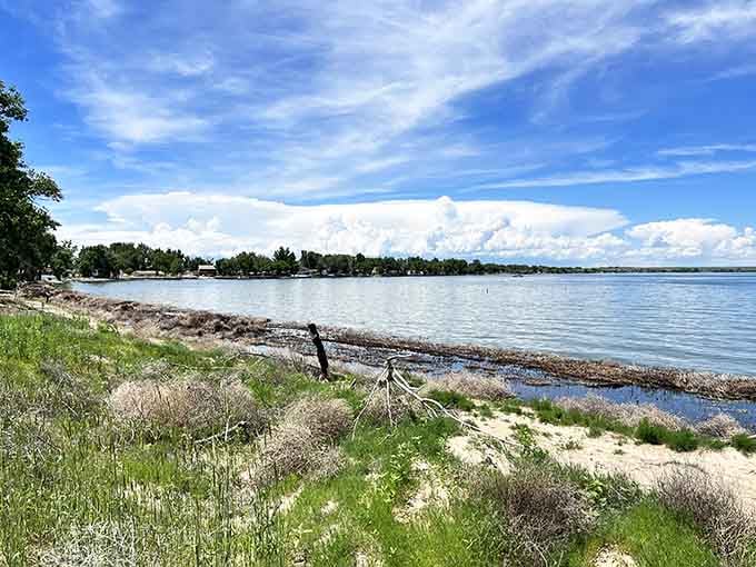 The sandy shoreline at Jackson Lake State Park stretches along calm blue waters under big prairie skies perfect for relaxing.