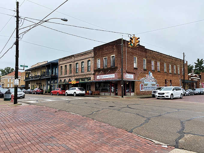 The vintage theater marquee glows against aged brick, a reminder that entertainment once meant gathering together as neighbors.