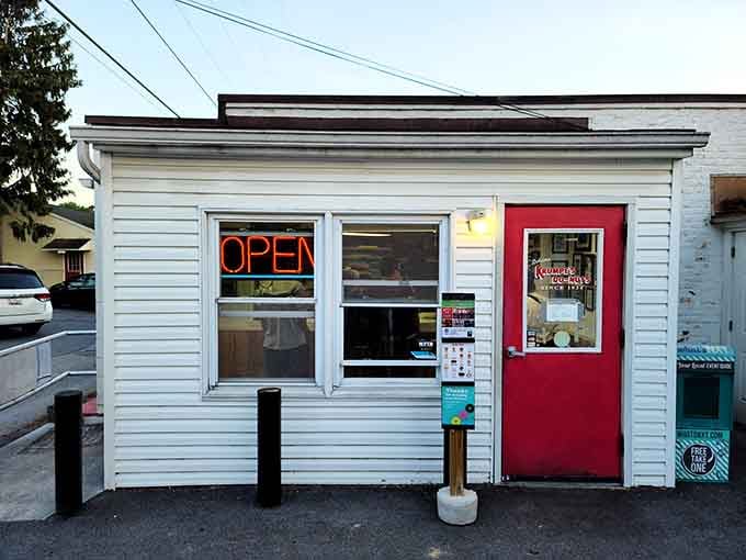 The red door and simple white siding hide a late-night donut operation that's been defying normal hours forever.