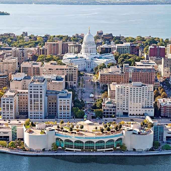 From above, Madison spreads between shimmering lakes, a city that understood location matters long before real estate agents.