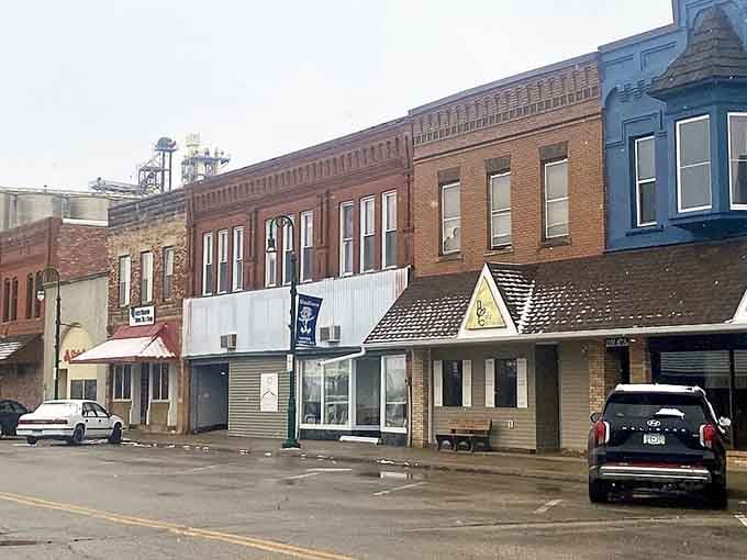 Historic storefronts wear their age with dignity, standing shoulder-to-shoulder like old friends sharing secrets across the decades.