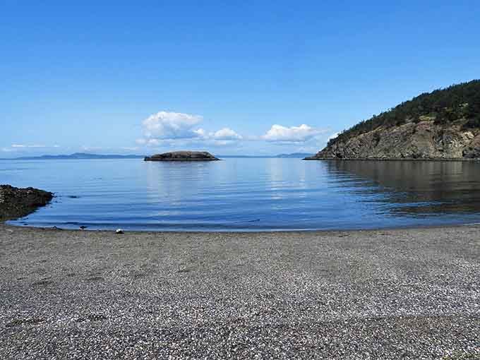 That mirror-smooth water and tiny island create a scene straight from a postcard you'd actually send.