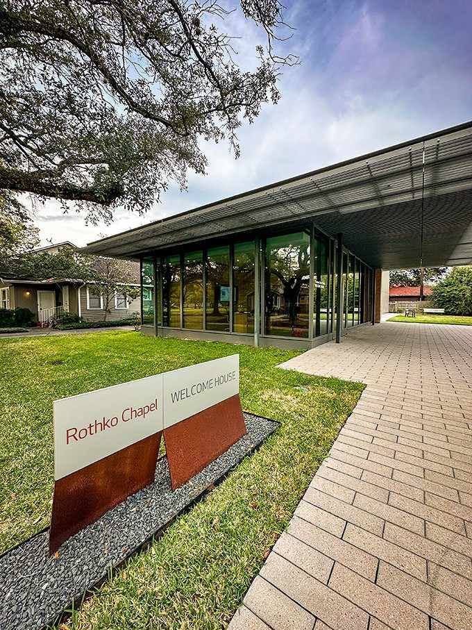 Modern glass walls invite natural light to dance across the entrance, welcoming seekers of quiet reflection.