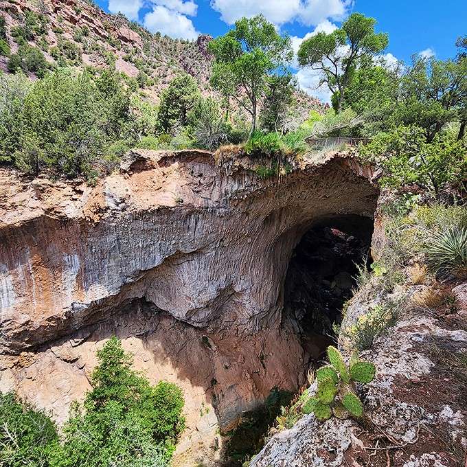 Trees crown this natural bridge where layers of travertine create an archway that defies your sense of scale.
