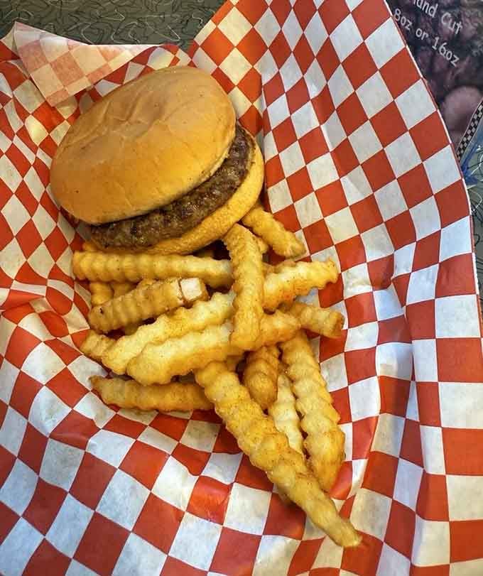 A classic burger with crinkle-cut fries in a red checkered basket is proof that some things never go out of style.