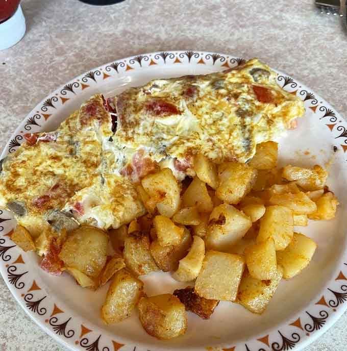 This veggie omelet arrives loaded with fresh ingredients and zero regrets about your choices.