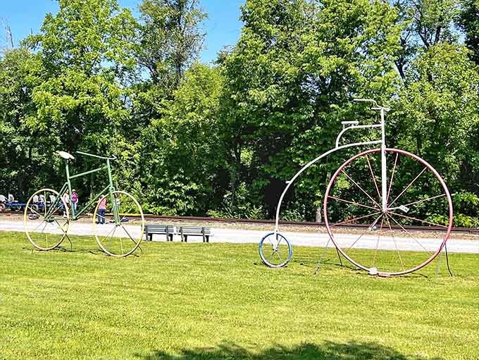 Those vintage bicycle sculptures celebrate cycling history while modern rail bikers create their own memories just beyond the frame.