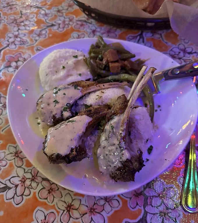 Lamb chops frenched and plated like edible architecture, proving elegance thrives even in rural taverns.