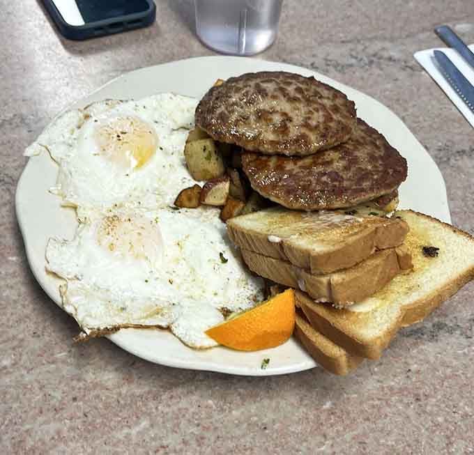 Two sunny-side-up eggs with sausage patties that look like they mean business, the kind of plate that fuels legends.