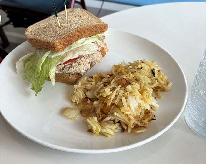 Tuna salad sandwich paired with golden hash browns proves lunch can be just as nostalgic as breakfast.