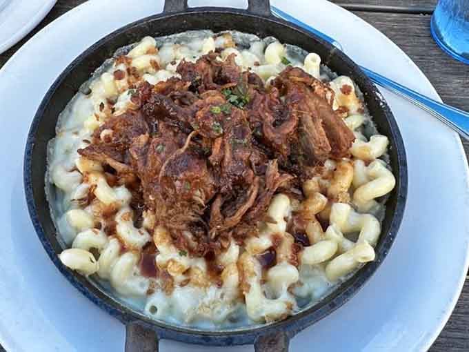 Mac and cheese topped with BBQ pork in a skillet, because sometimes more is actually more, not less.